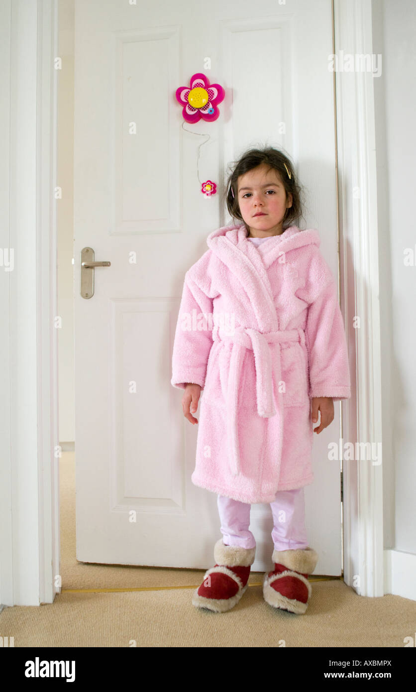 Sick child stands outside bedroom door wearing gown Stock Photo - Alamy