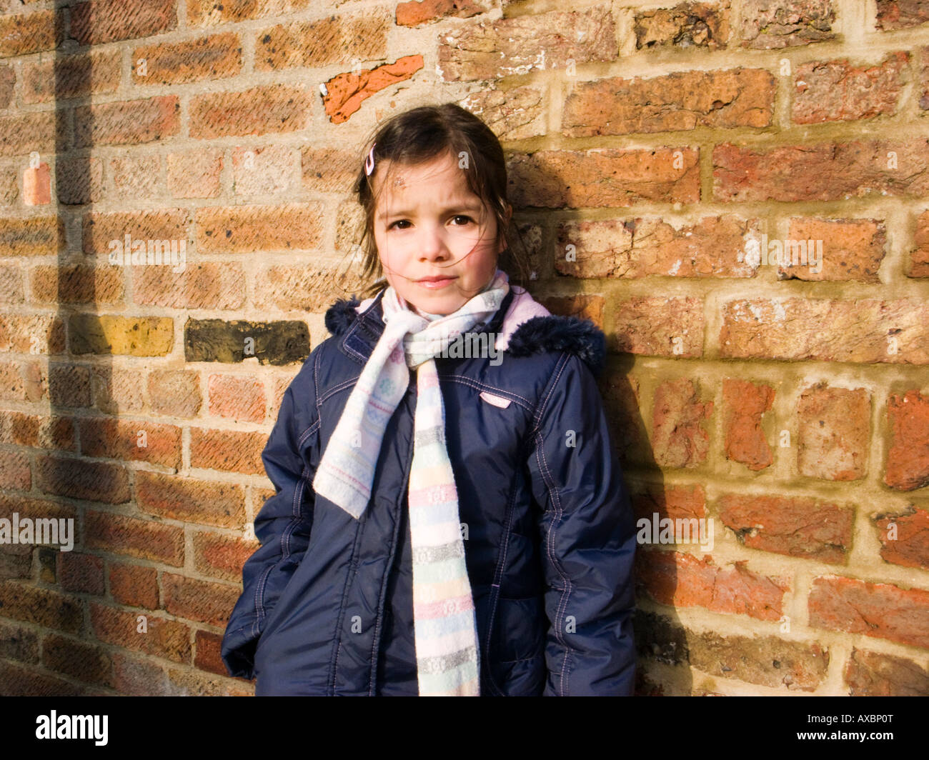 child stands by a brick wall Stock Photo - Alamy