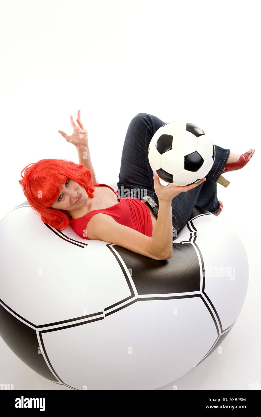woman with red wig and soccer ball sitting on a soccer chair Stock ...