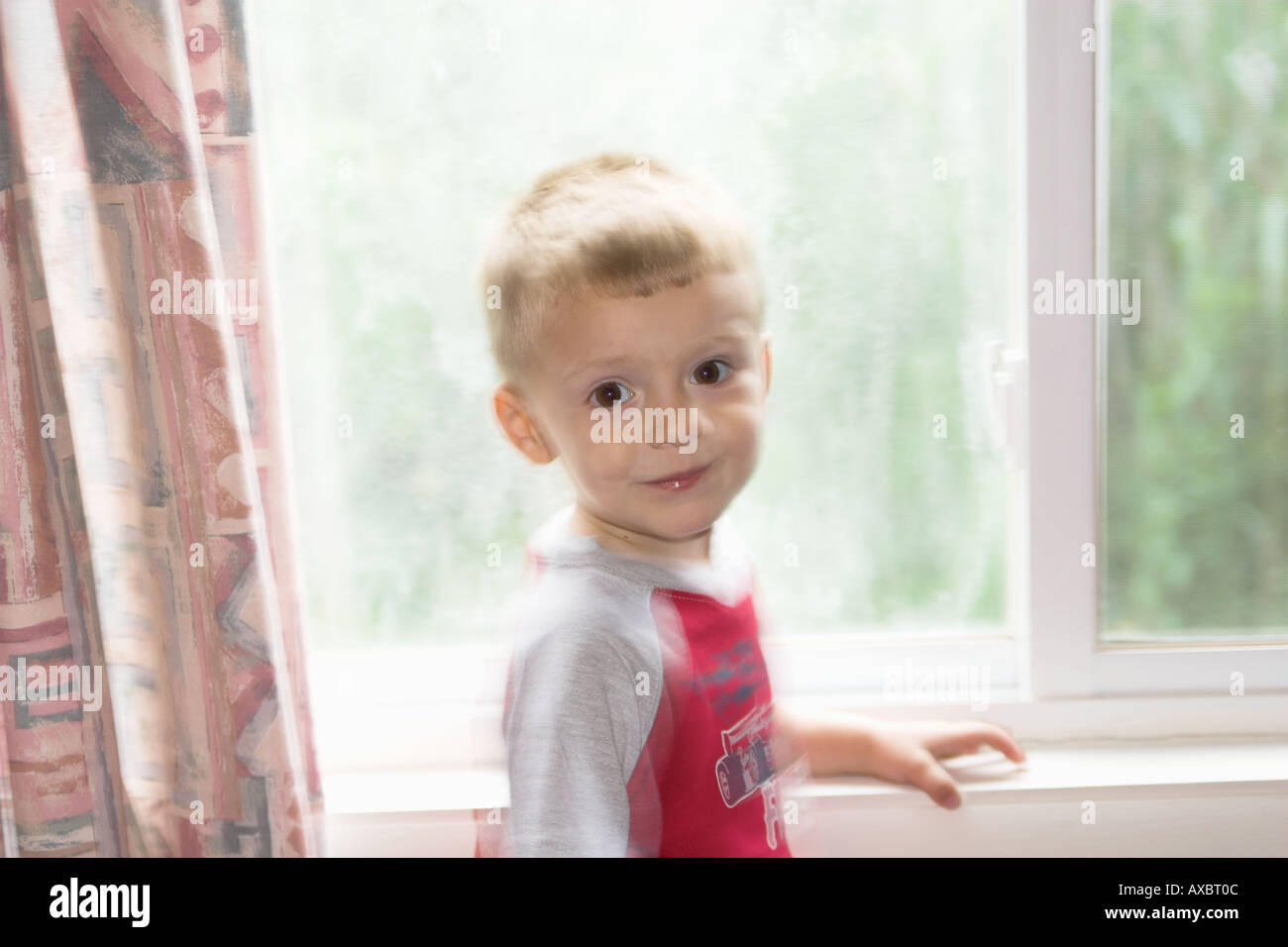 Little boy standing by window Stock Photo - Alamy