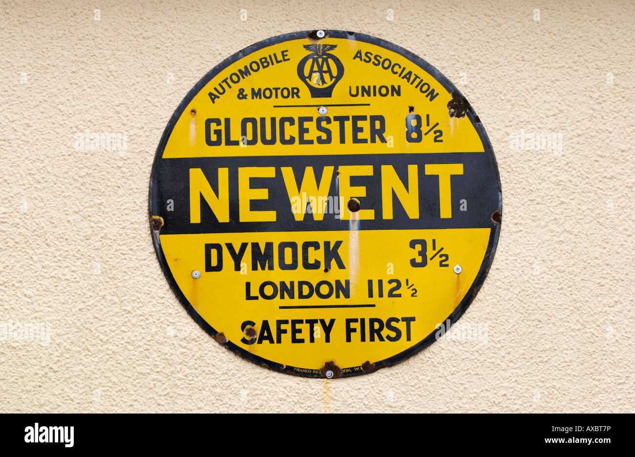 Old yellow and black AA distance sign fixed to house wall at Newent ...