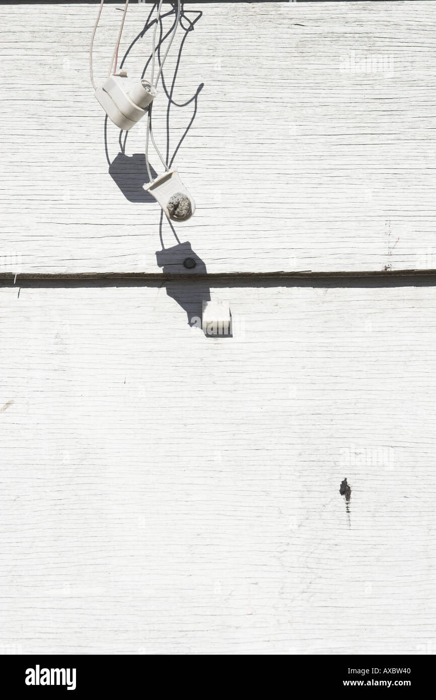 Wires dangle on white painted wooden wall, vertical Stock Photo - Alamy