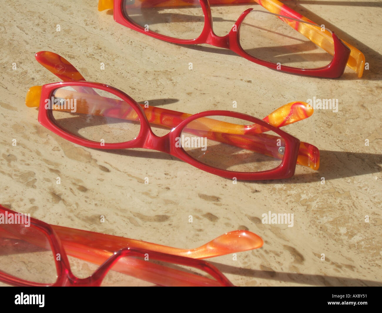 three colourful orange spectacles at opticians Stock Photo - Alamy