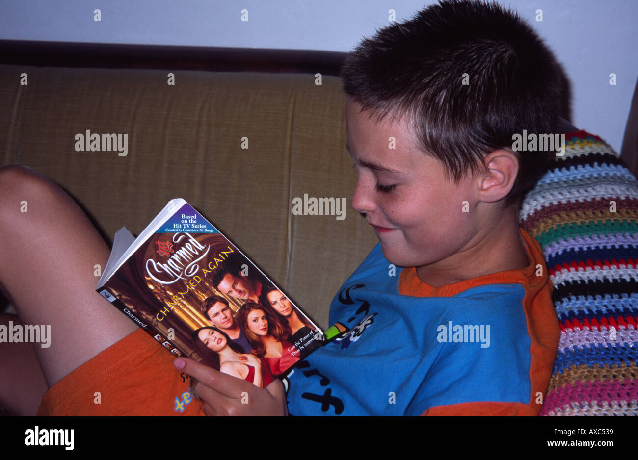 Boy reading a fiction book on sofa, London, England UK Stock Photo - Alamy