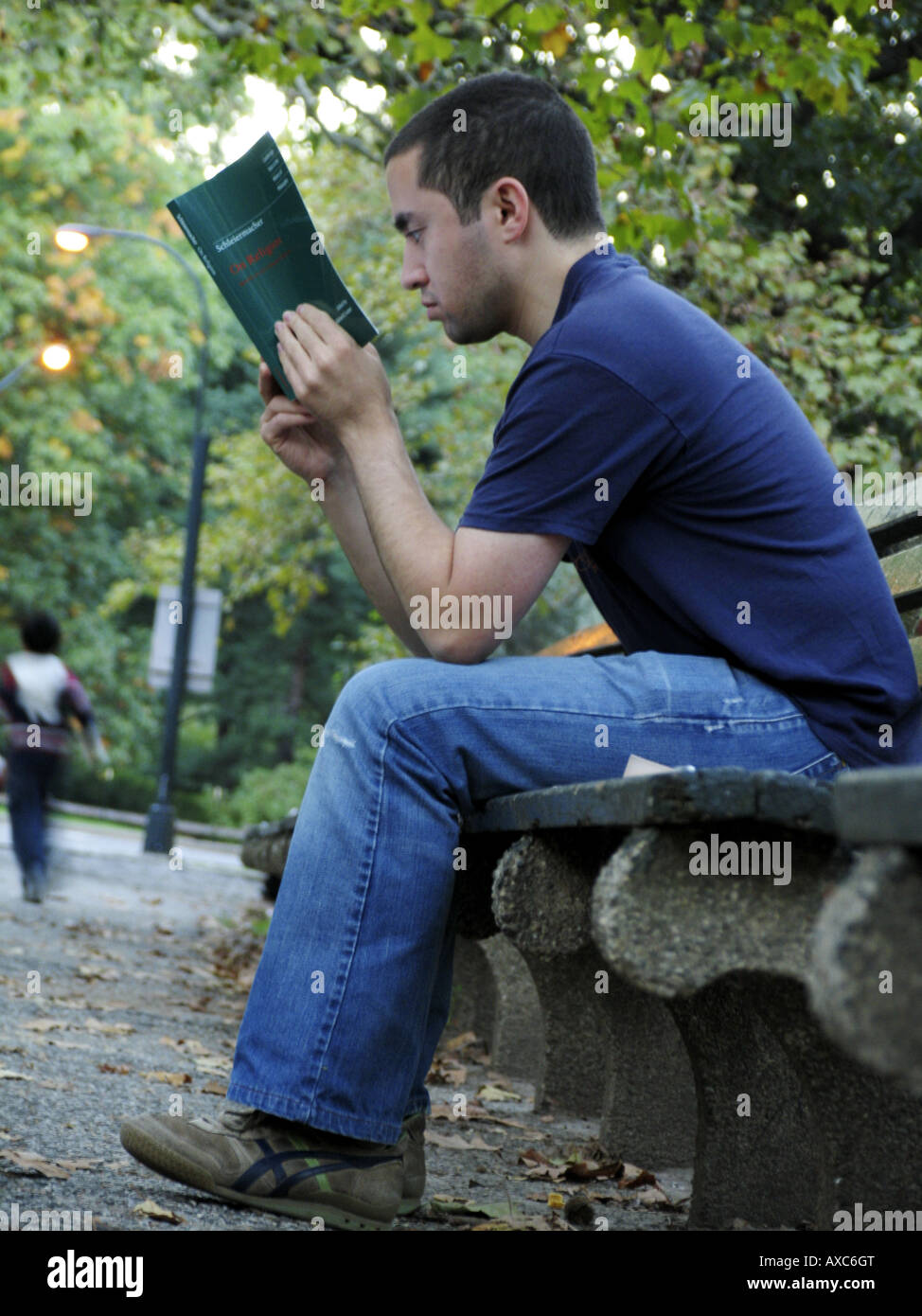 young man reading a book in the Central Park, USA, Manhattan, New York ...