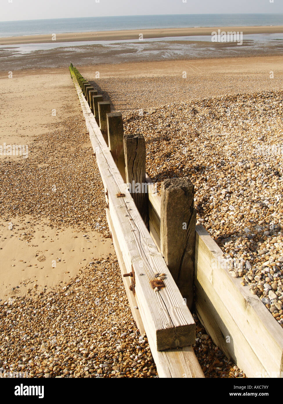 pebble wooden wood sea defence low tide beach camber sands kent england ...