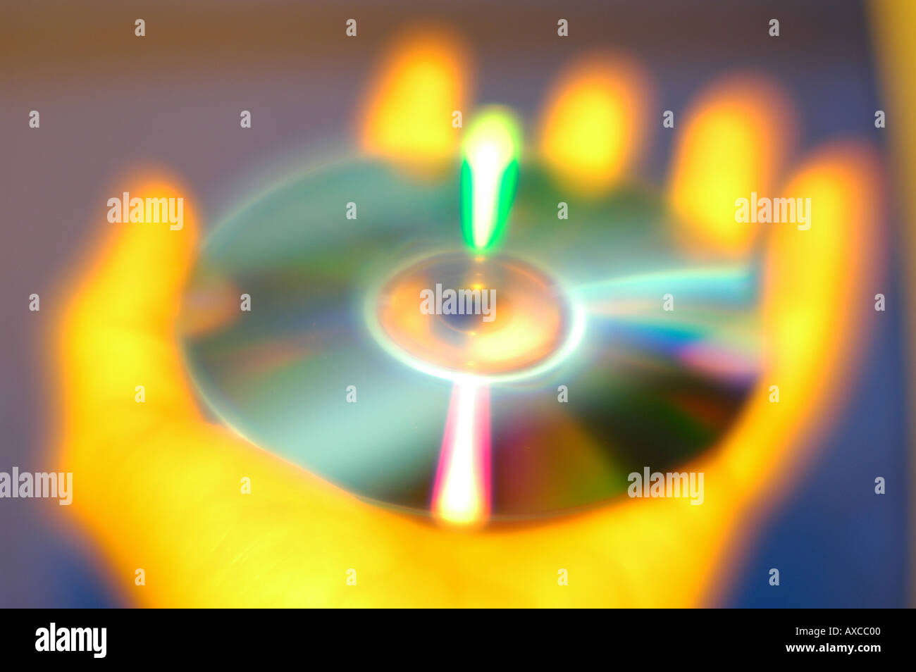 Hand holding computer disc stylized with yellow light and color Stock ...