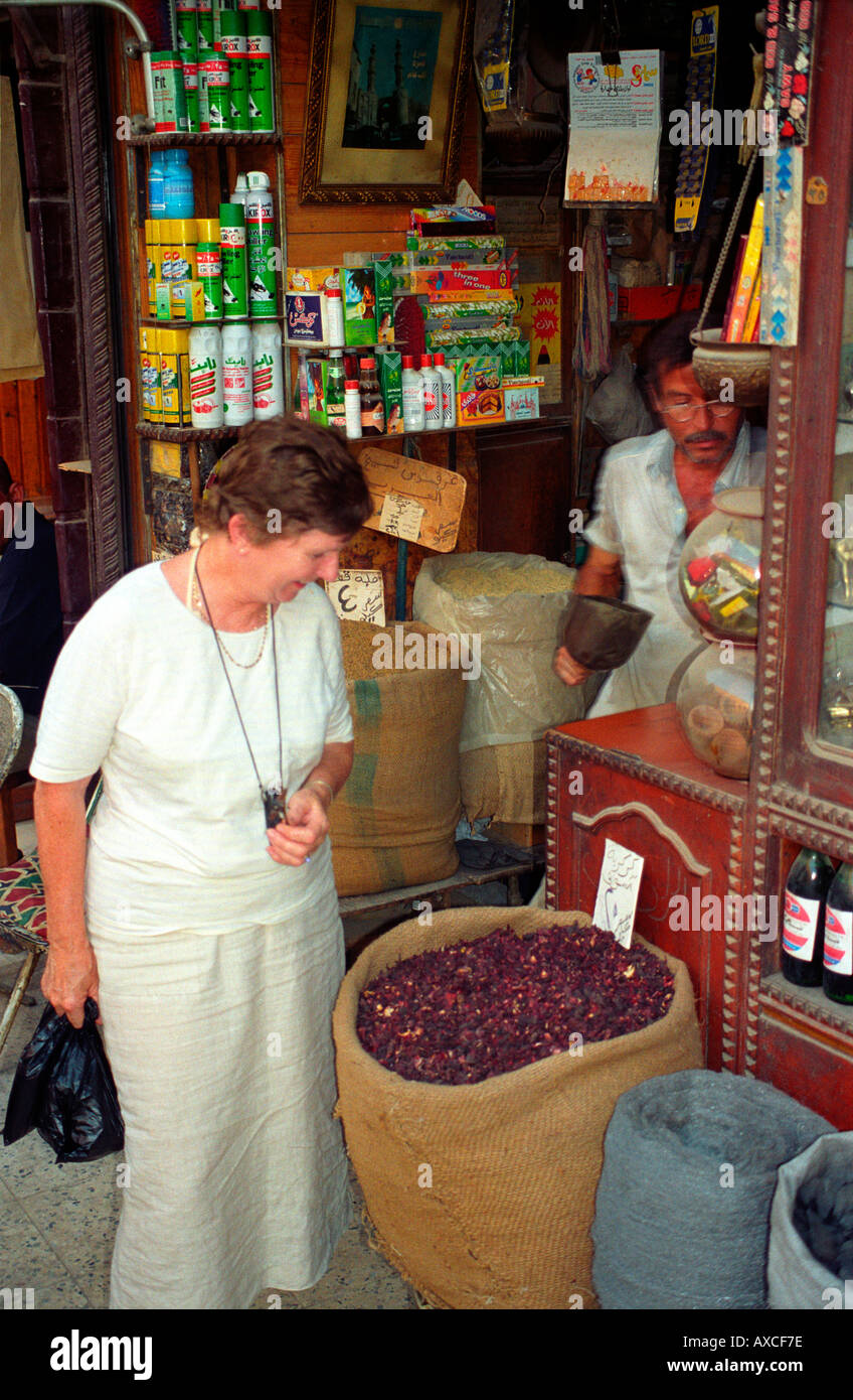 Toursit selecting from hundreds of varieties of tea in a Cairo market ...