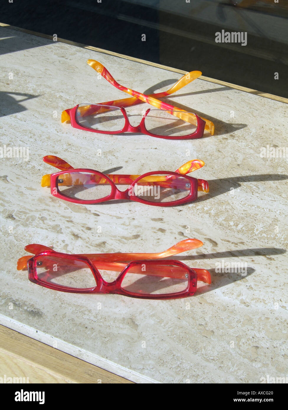 three colourful orange spectacles at opticians Stock Photo - Alamy