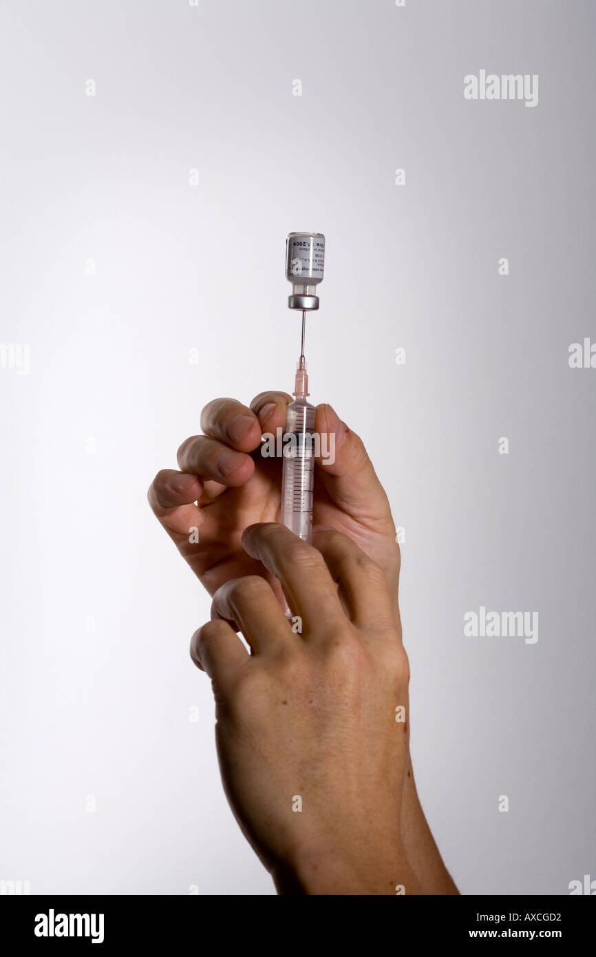 Pair of hands holding an injection needle Stock Photo - Alamy