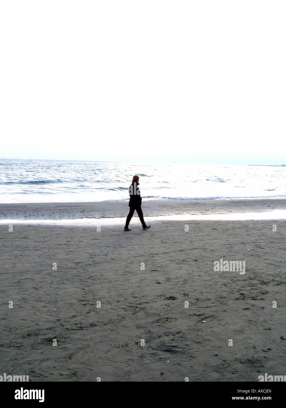 person walking on beach Stock Photo - Alamy