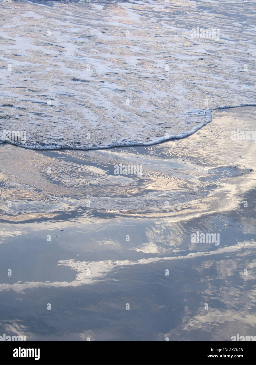 waves lapping up on sea shore Stock Photo - Alamy