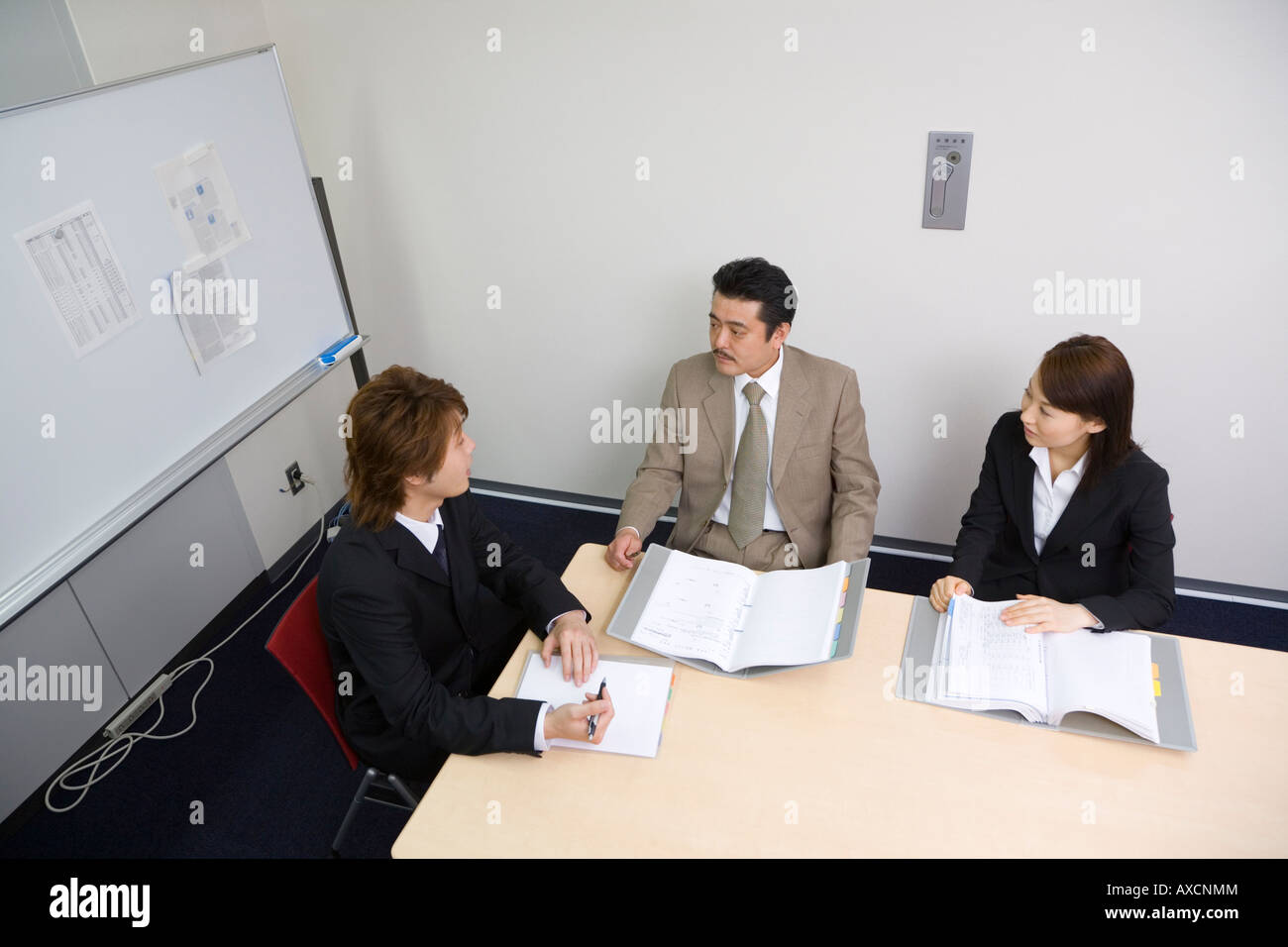 Three people discussing in meeting room Stock Photo - Alamy