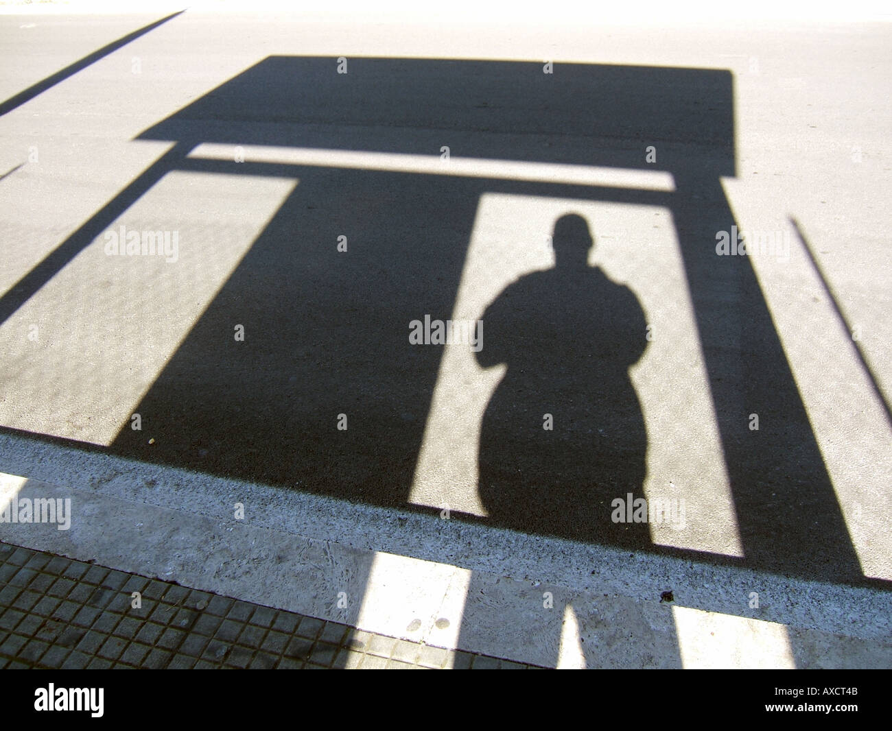 shadow of man waiting at bus stop Stock Photo - Alamy