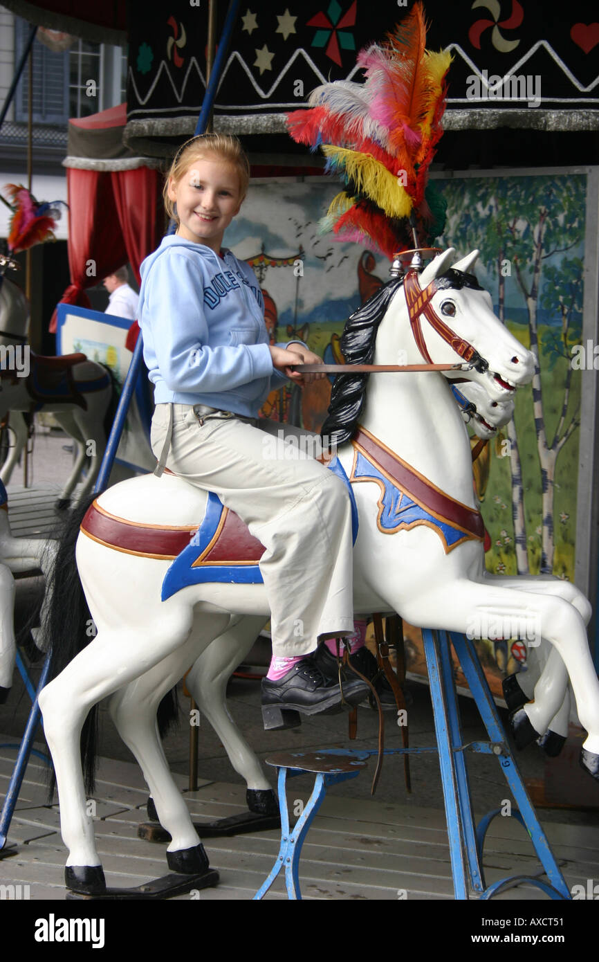 Young girl on horse on fairground carousel Stock Photo - Alamy