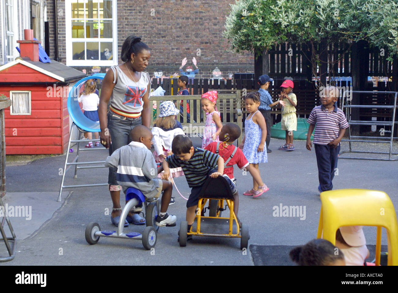 nursery playground with teacher and children playing Stock Photo - Alamy
