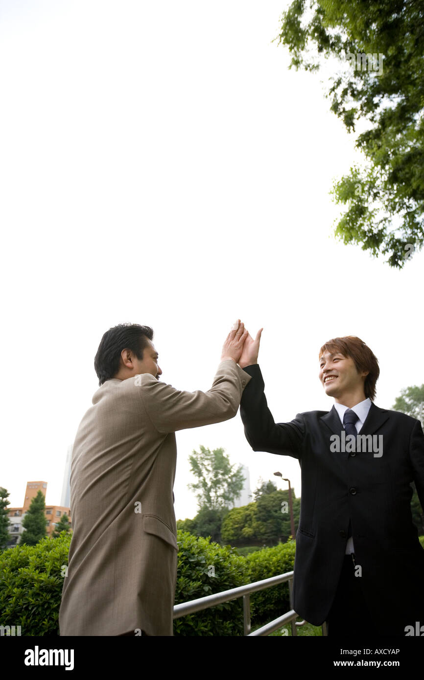 Two businessmen doing high-five Stock Photo - Alamy
