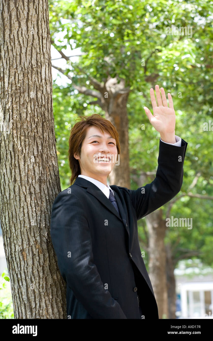 Young businessman waving hand Stock Photo - Alamy
