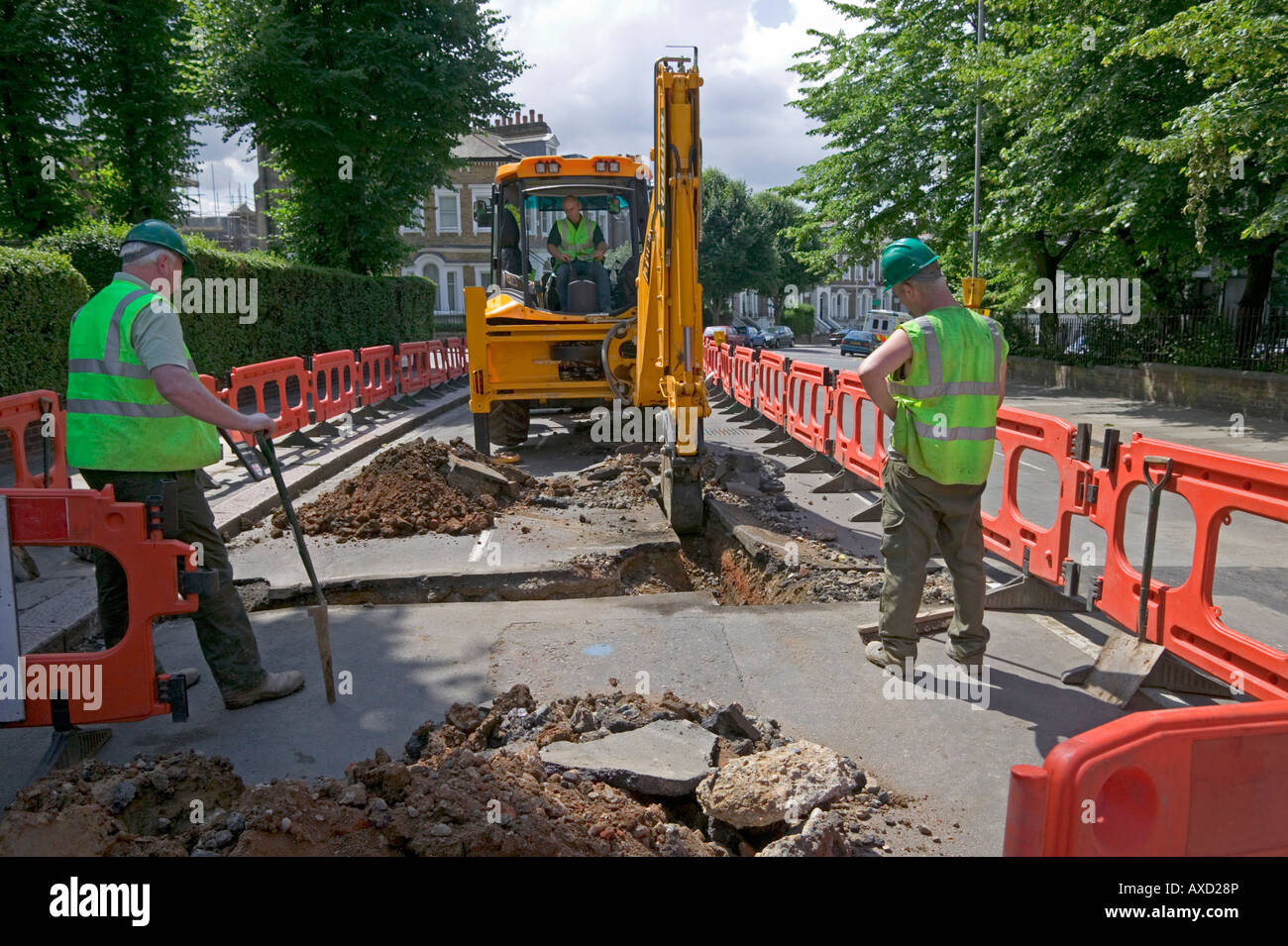 Excavating trench behind traffic barrier in preparation for installing ...