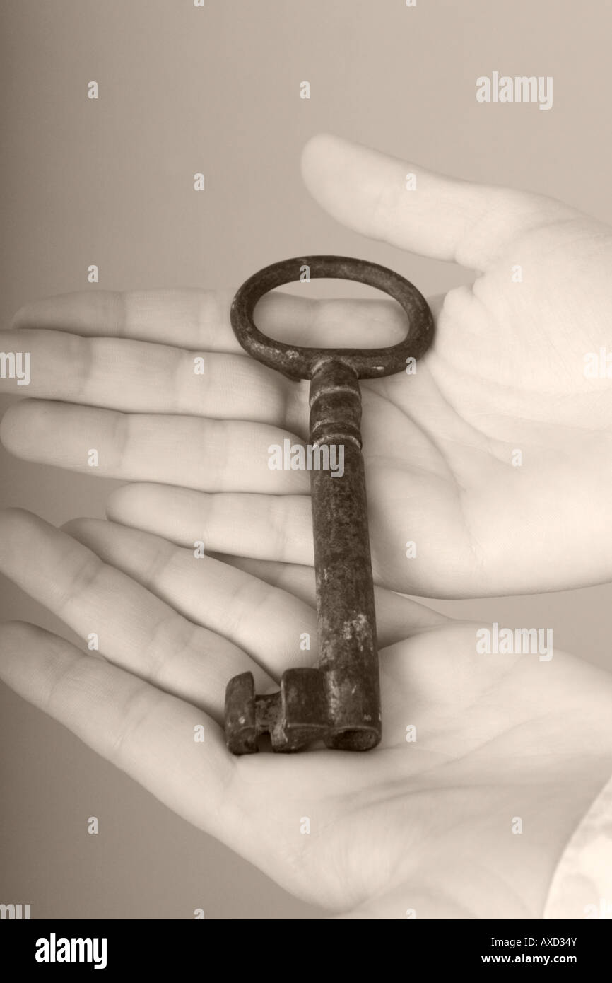 Holding a large old key in the palm of hands Stock Photo - Alamy