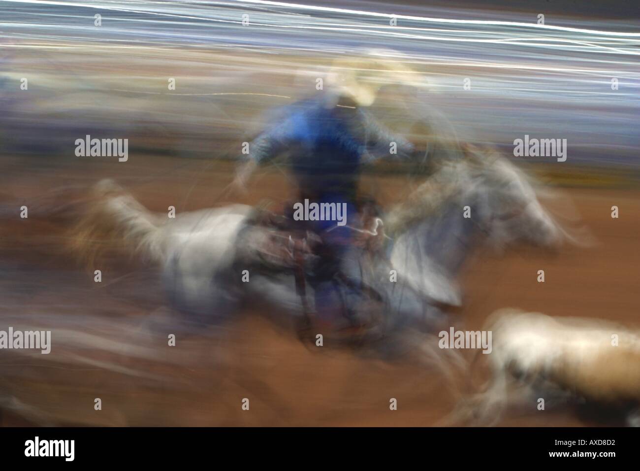 This blurred image of a cowboy during a rodeo competion brings motion ...
