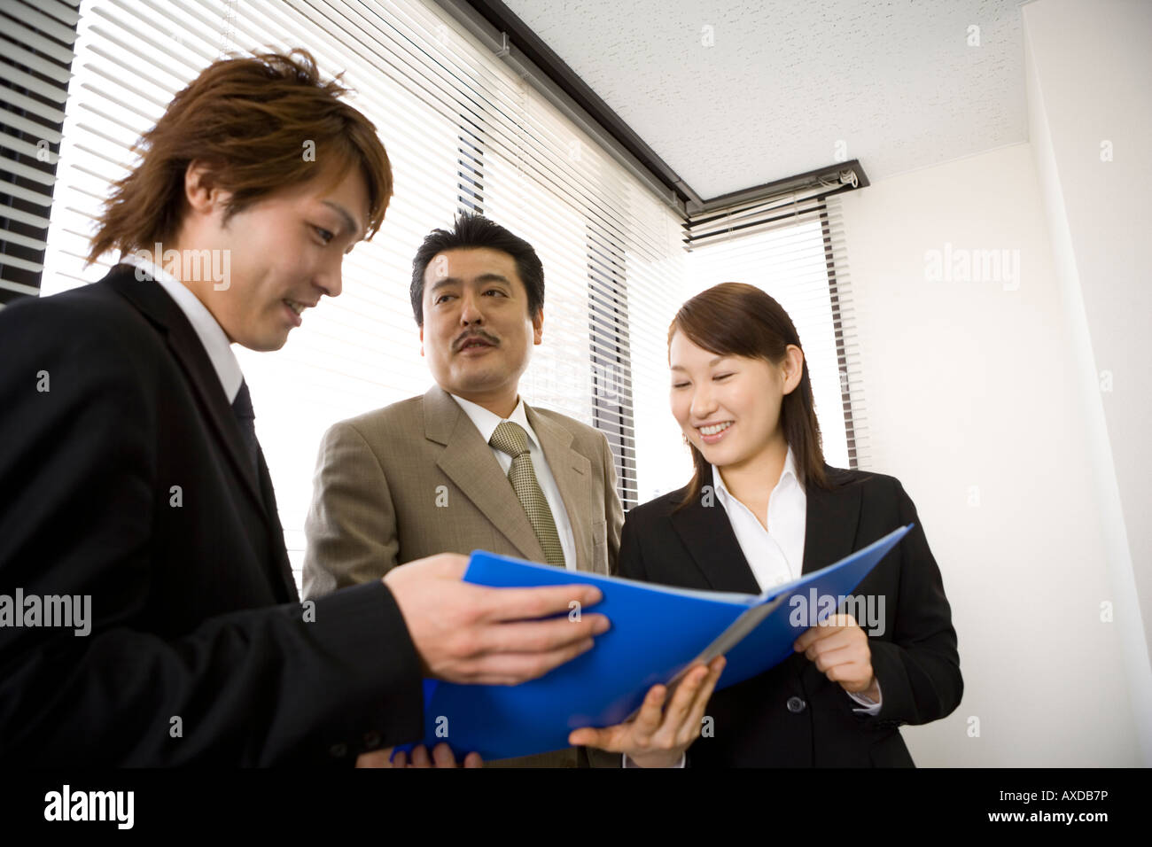 Three people talking in office Stock Photo - Alamy
