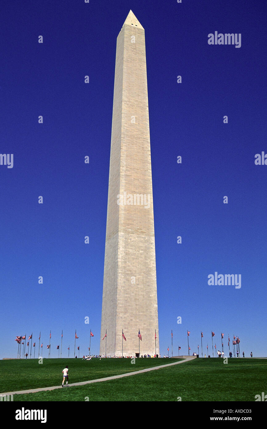 Runner jogs up path toward Washington Monument and ring of USA flags ...