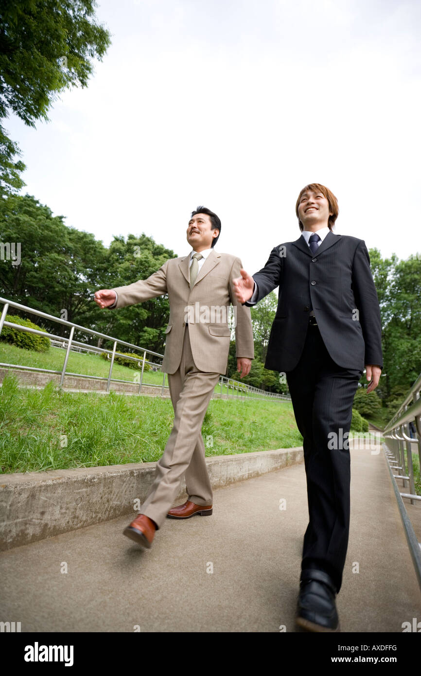 Two businessmen walking Stock Photo - Alamy