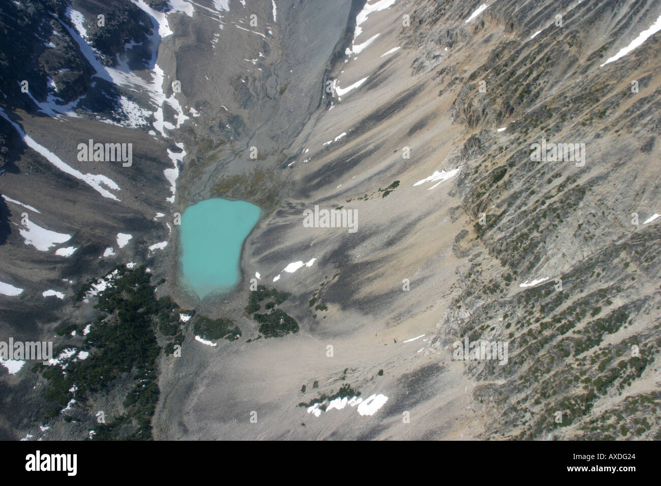 Aerial view of a vivid blue lake in the mountains of British Columbia ...