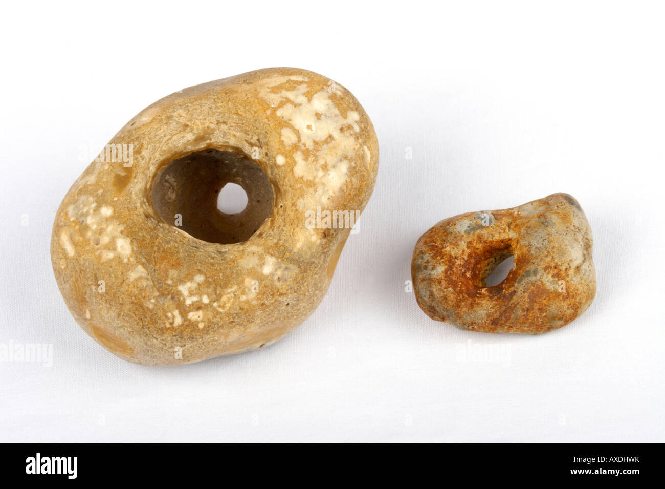 Two stones with natural holes in on plain white background Stock Photo ...