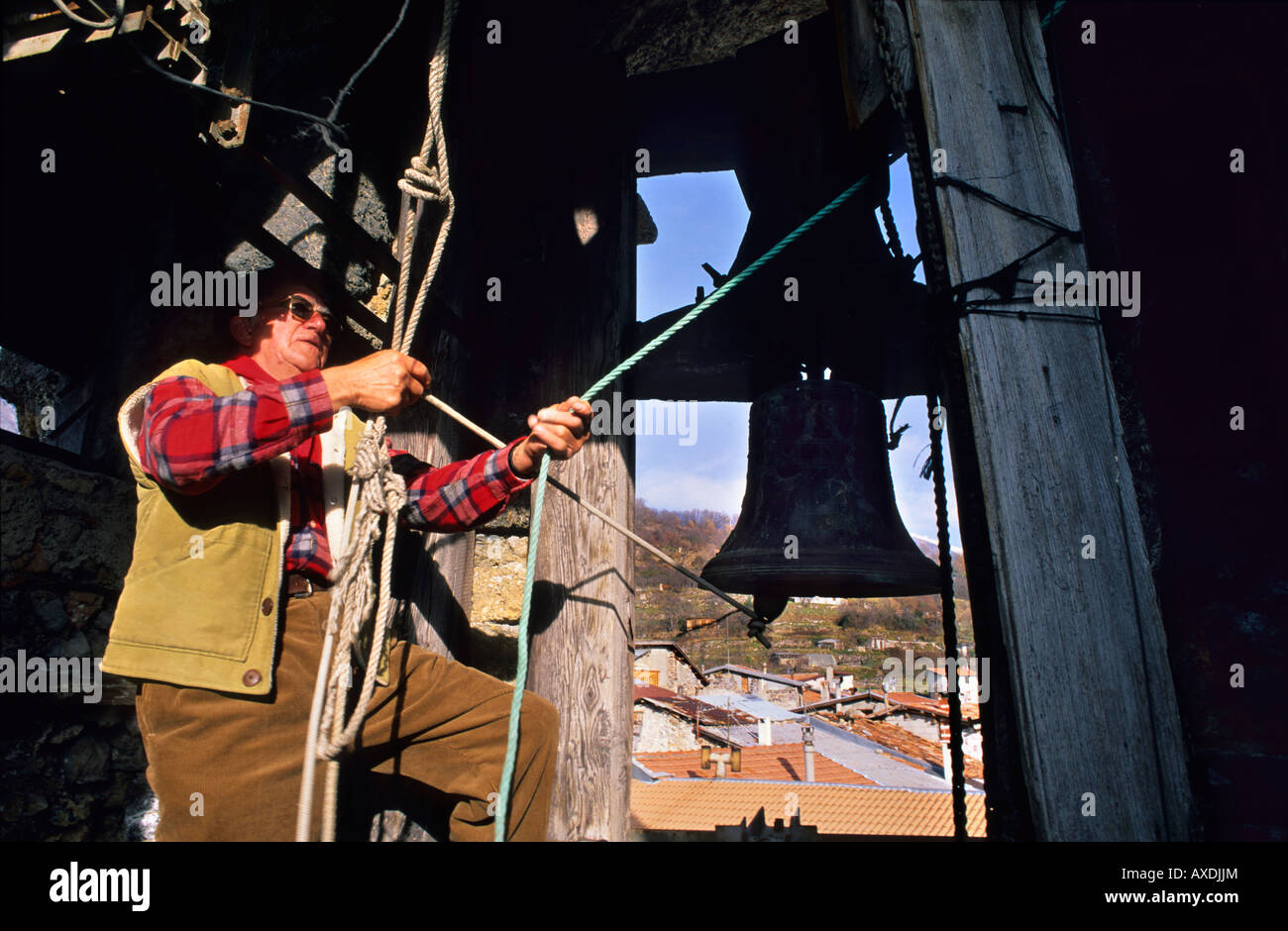 Man ringing the bells inside a church bell tower in Belvédère, French ...