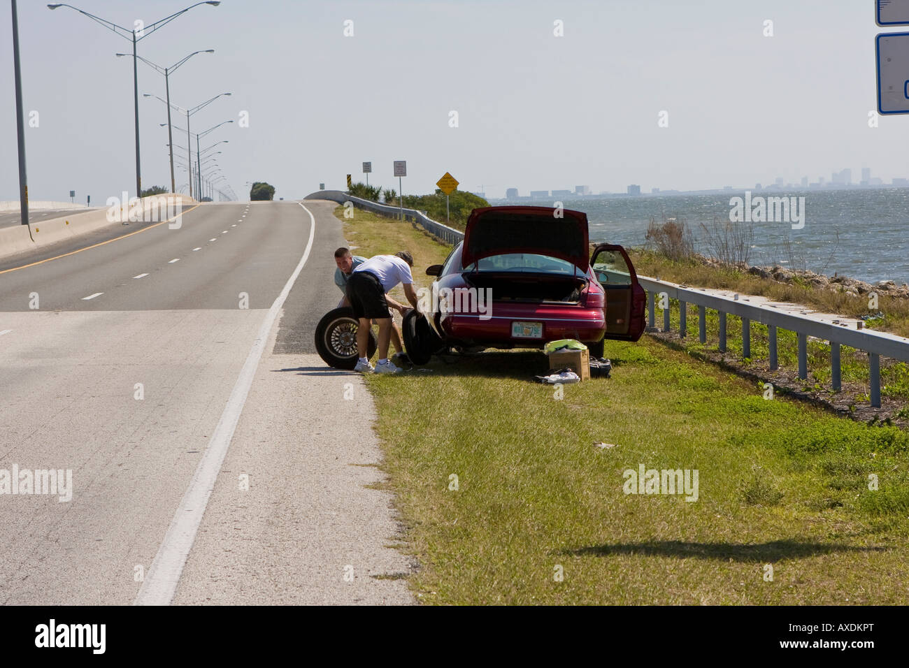 Two Men Changing a Tire on the Side of a Highway Stock Photo - Alamy