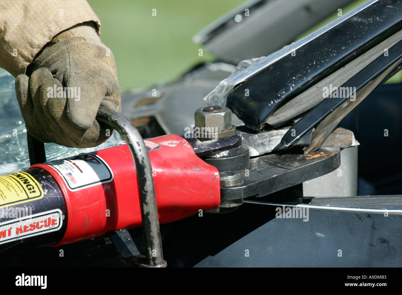 A fire fighter is using a powerful cutting machine to cut into a car to ...
