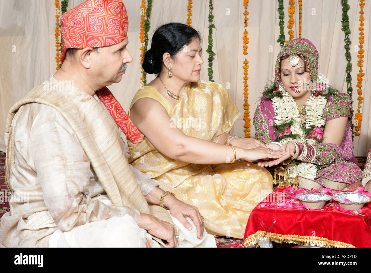 Bride getting married with her parents sitting besides her Stock Photo ...