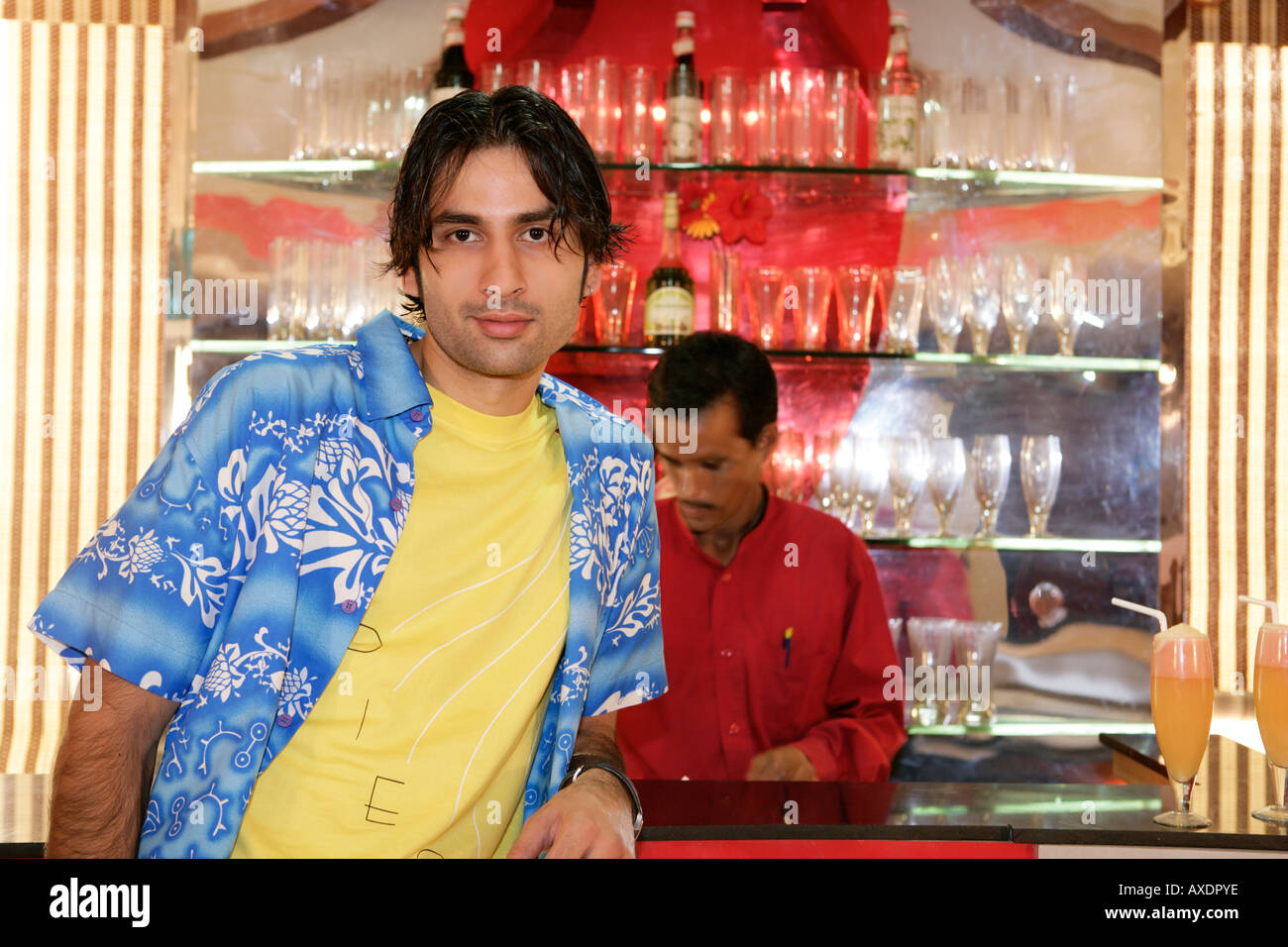 Portrait of a young man standing at a bar counter Stock Photo - Alamy