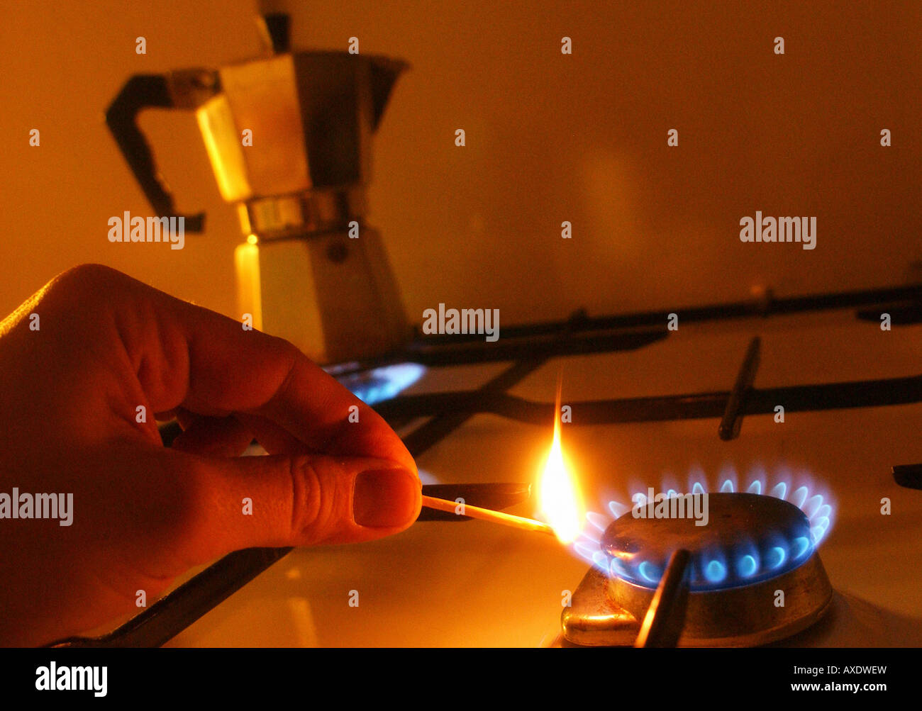Hand lighting a burner with a match Stock Photo - Alamy