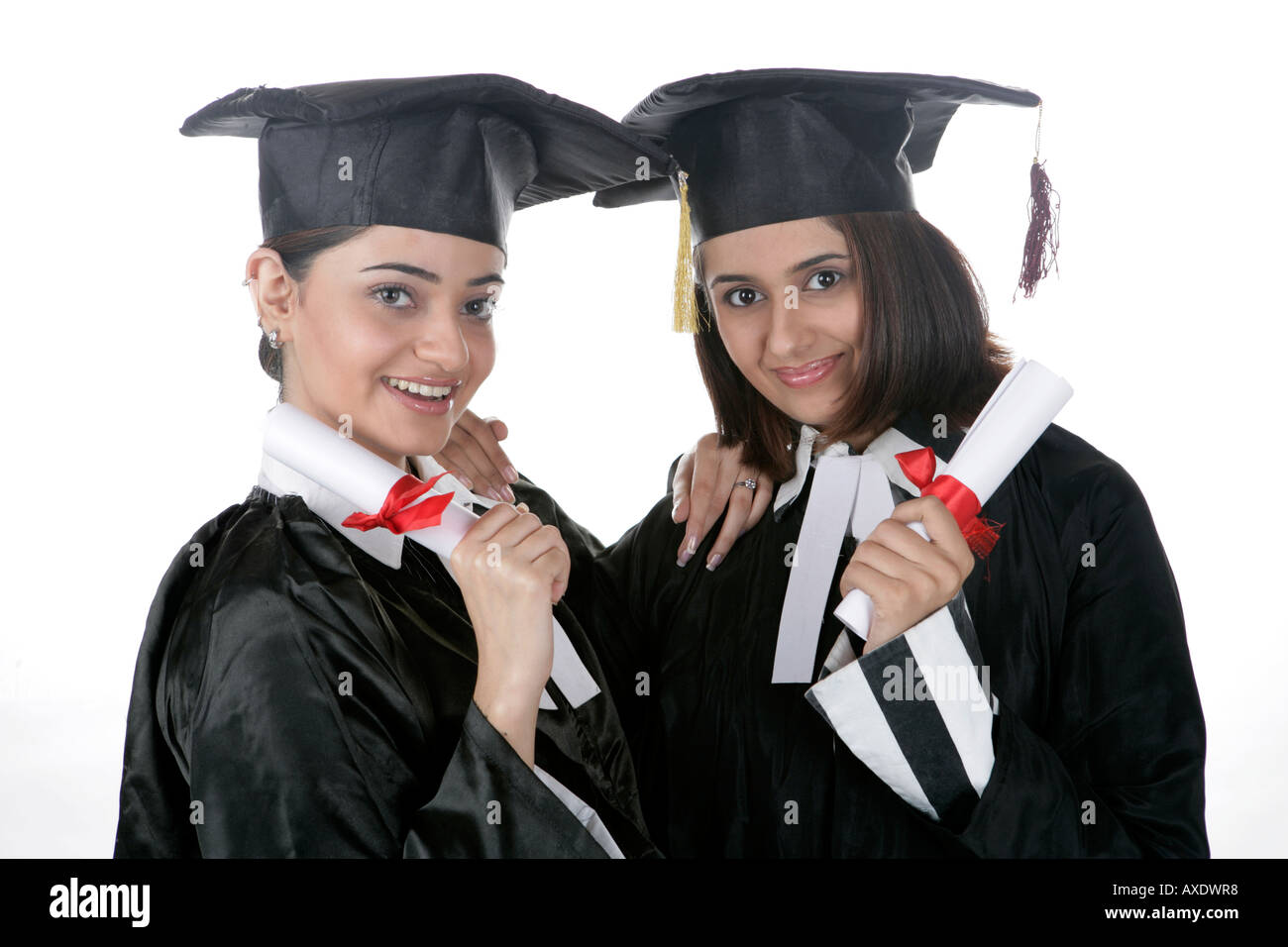 Portrait of two girls holding graduation degrees and smiling Stock ...