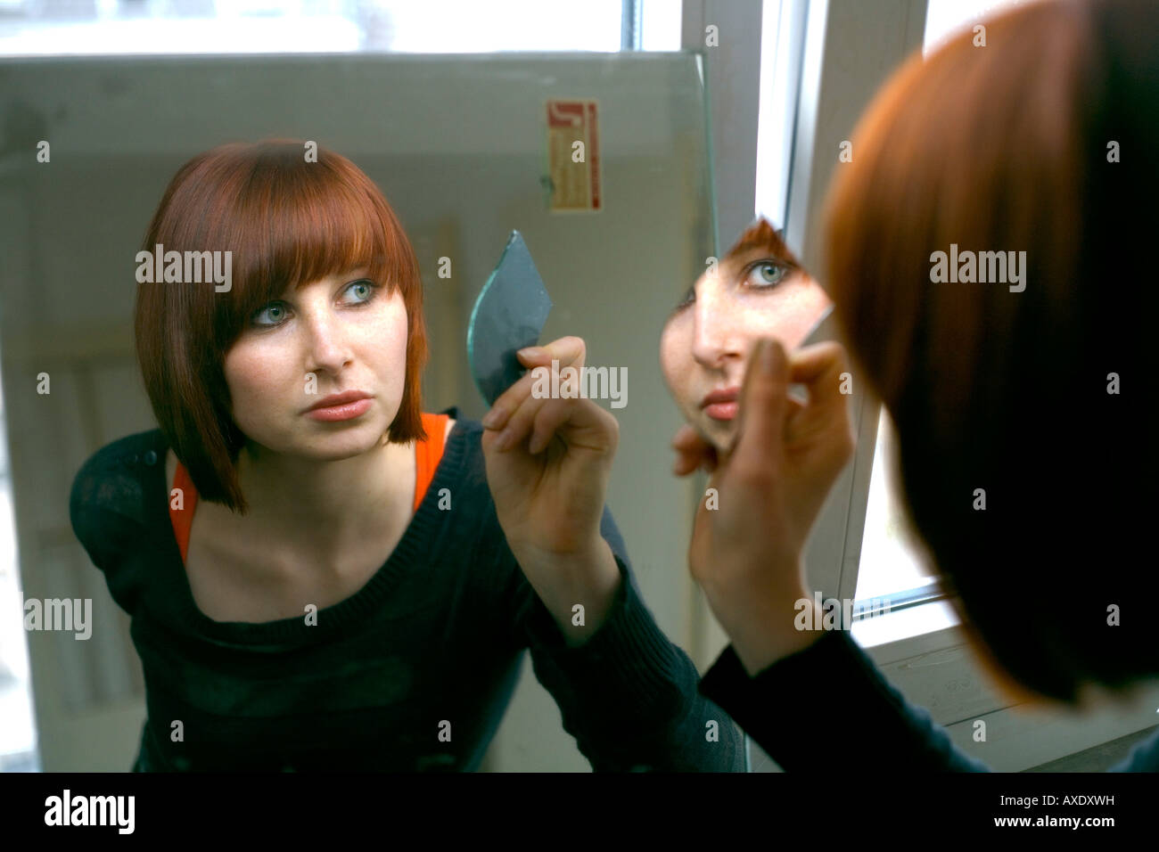 Woman looking into mirror, portrait Stock Photo - Alamy