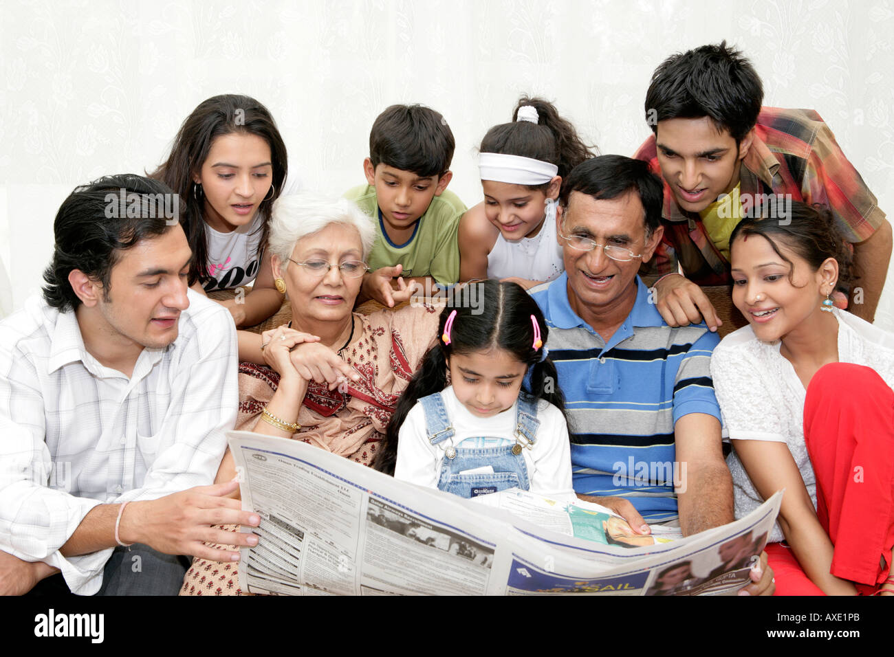 Joint family reading a newspaper Stock Photo - Alamy