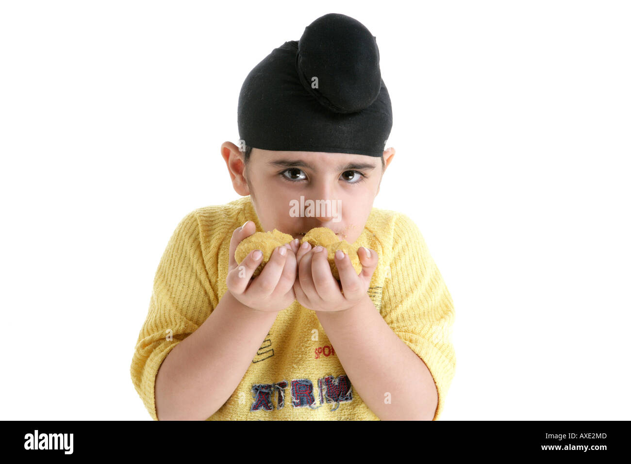 Portrait of a Sikh boy eating laddu Stock Photo - Alamy