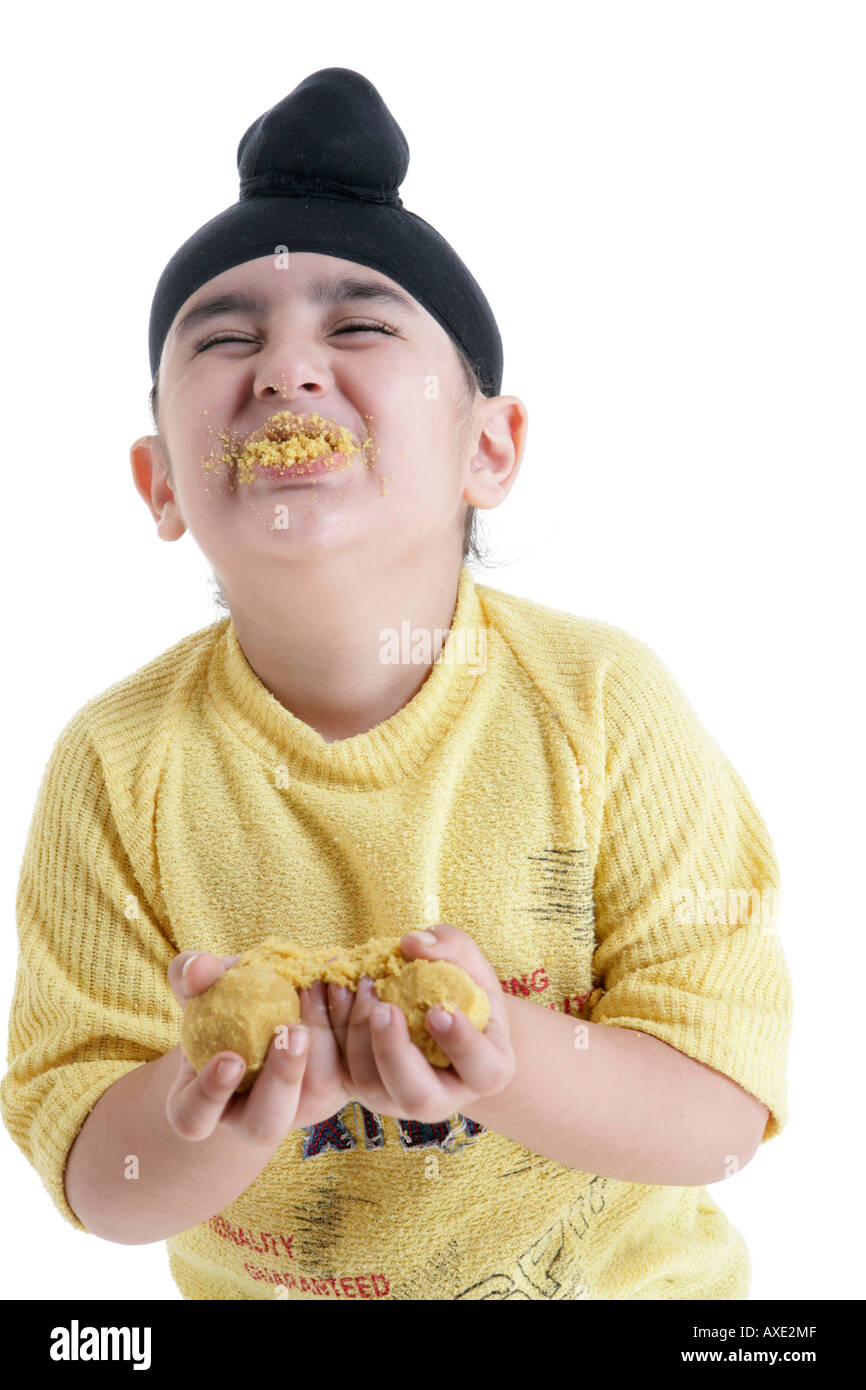 Close-up of a Sikh boy eating Laddu Stock Photo - Alamy