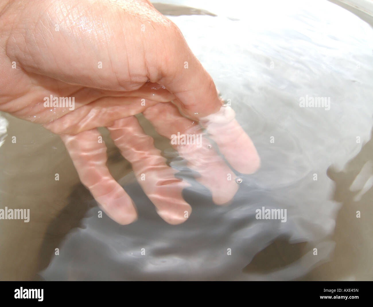 Hand touching water Stock Photo - Alamy