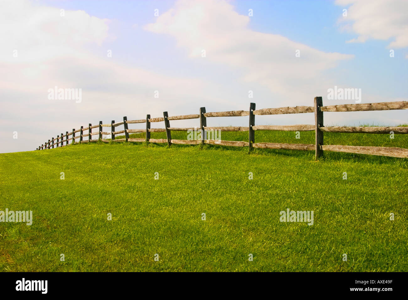 rolling green pasture with split rail fence Stock Photo - Alamy