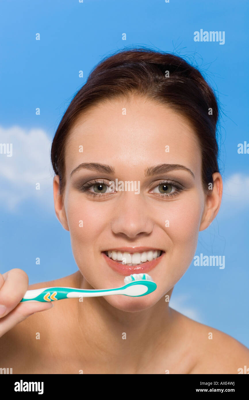 Young woman holding toothbrush, smiling, portrait Stock Photo - Alamy