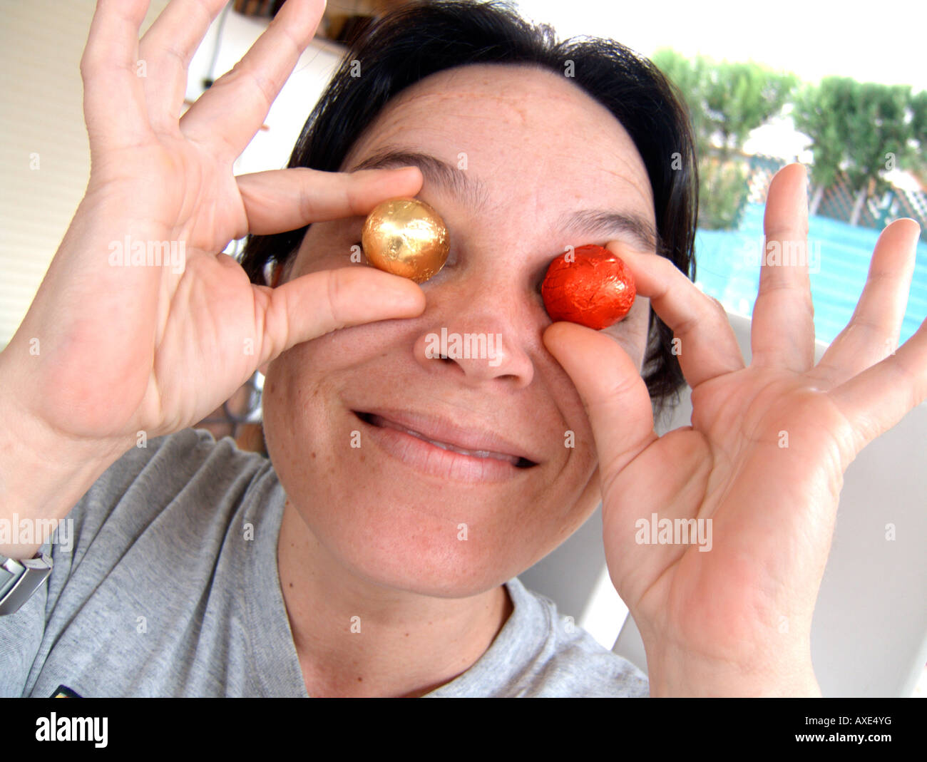 Woman hiding her eyes behind candies Stock Photo - Alamy
