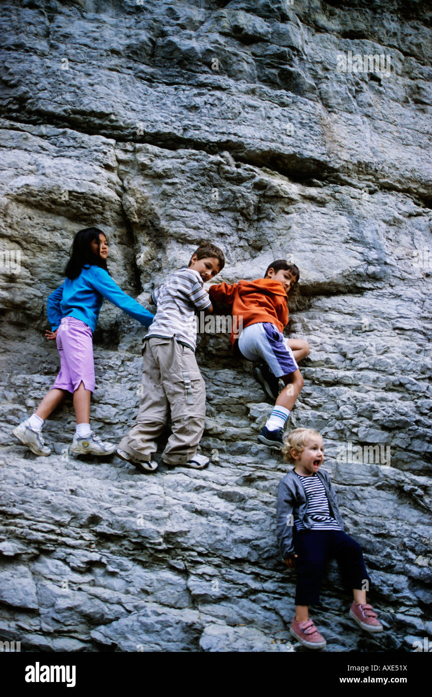 Four children climbing on a vertical cliff rock, France Stock Photo - Alamy