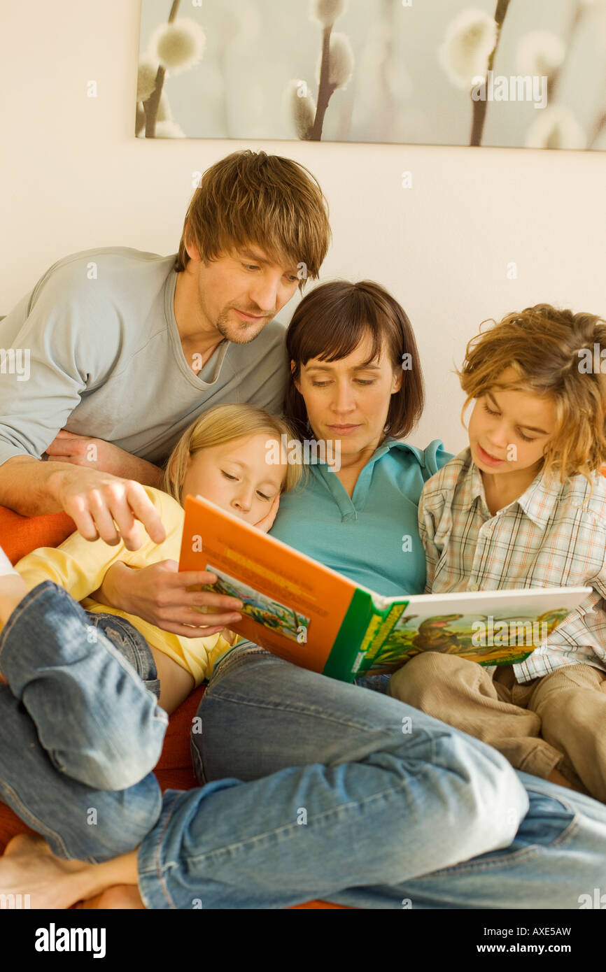 Family reading story book in living room Stock Photo - Alamy