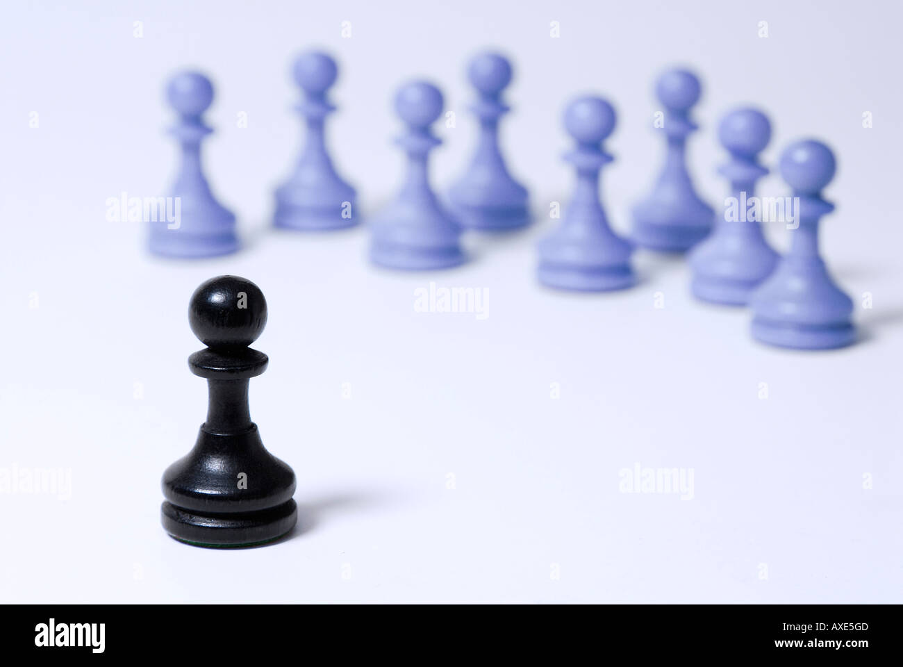 Chess, one black pawn stands in front of a group of blue pawns, symbol ...
