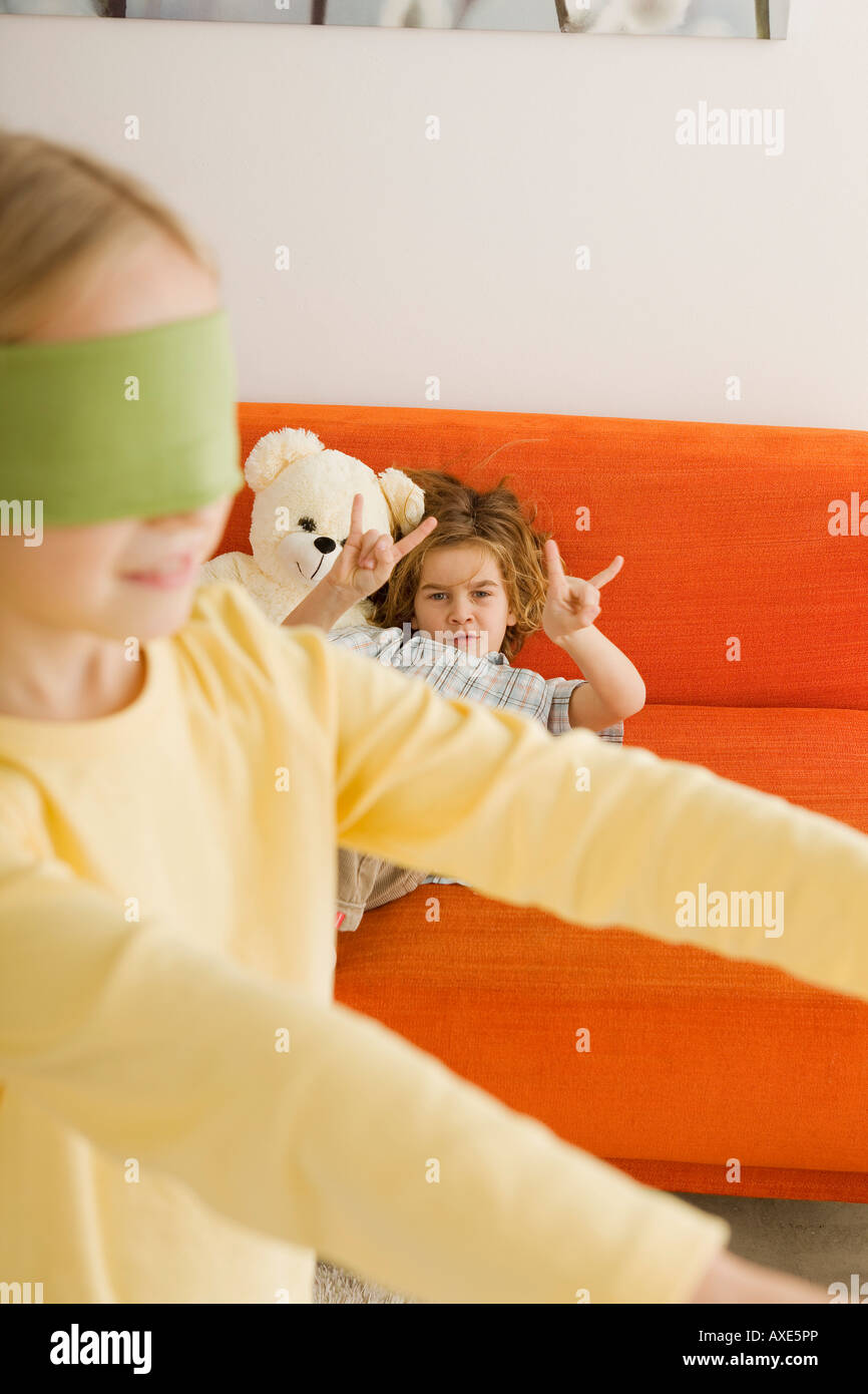 Boy (6-7) and girl (8-9) playing Blind Man's Bluff Stock Photo - Alamy