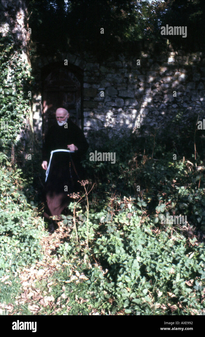 Monk walking in walled garden Stock Photo - Alamy
